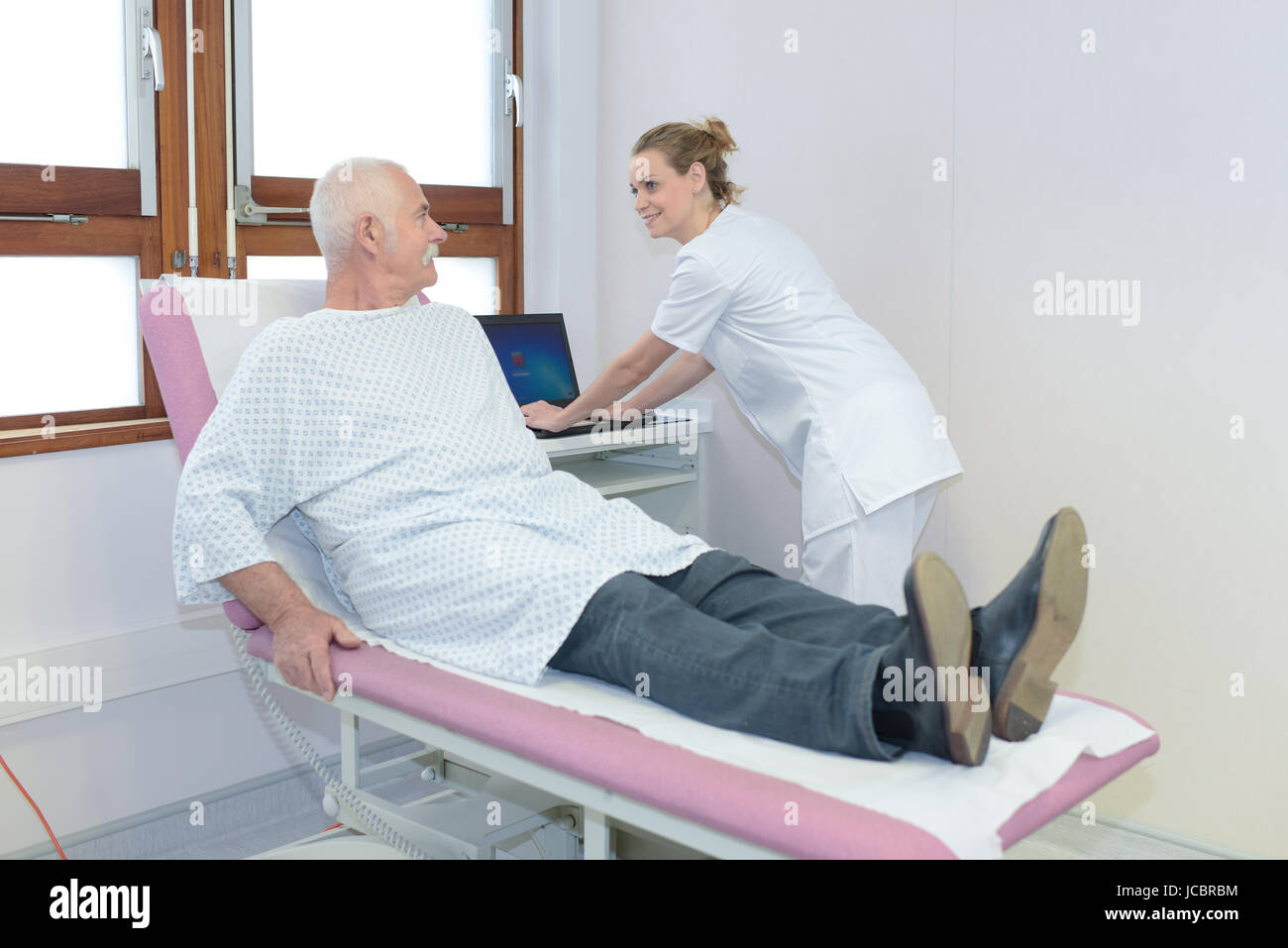 young female nurse showing test results to senior patient Stock Photo ...