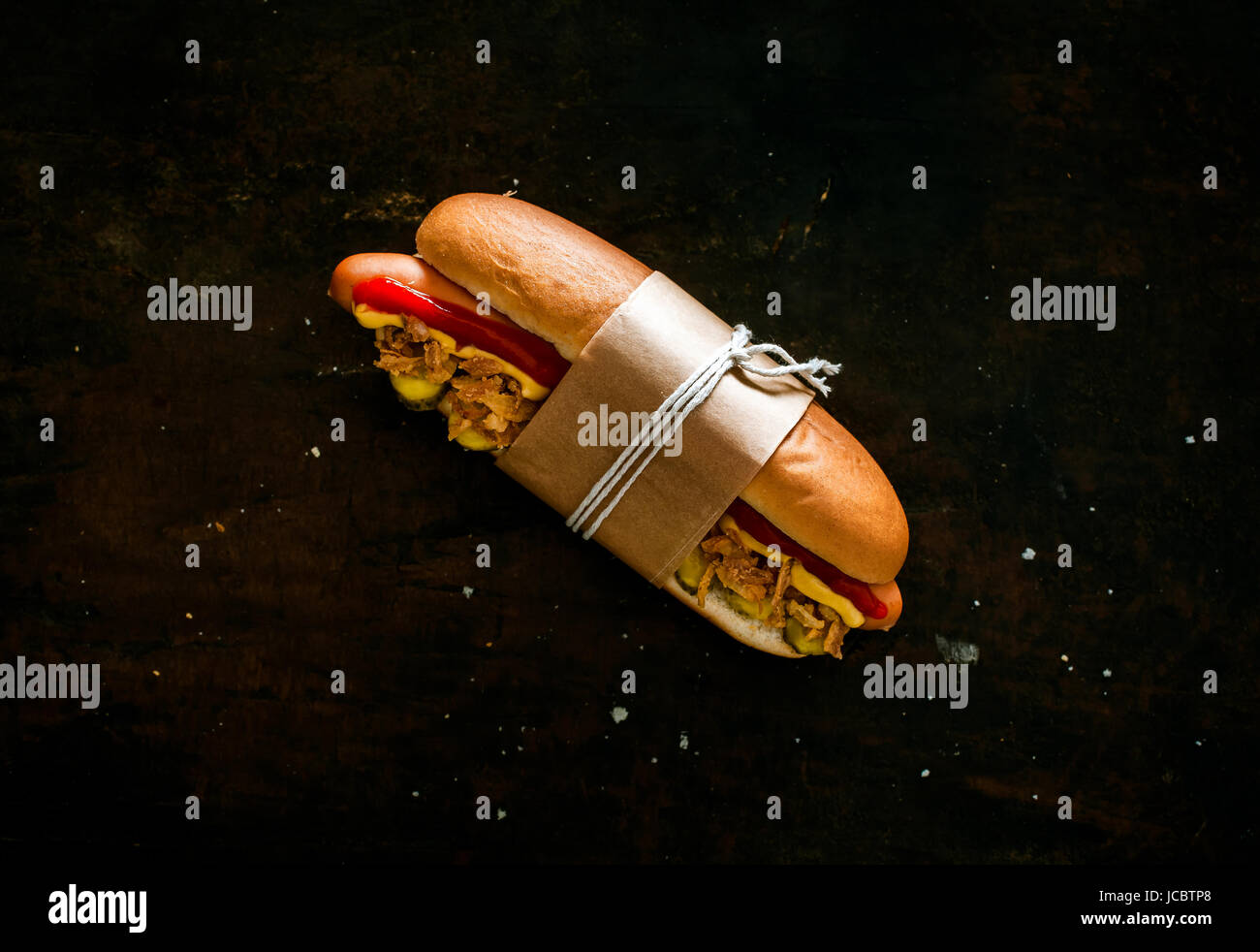 Takeaway hot dog with a smoked Wiener sausage and all the trimmings on ...
