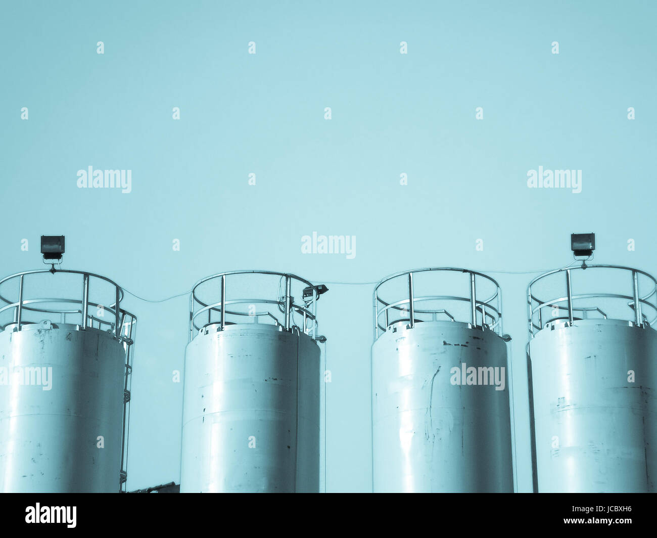 Yellow water tanks over a blue sky - cool cyanotype Stock Photo - Alamy