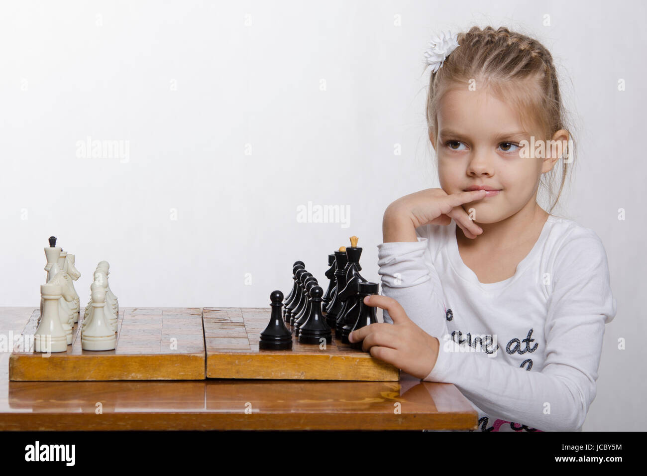 The girl sitting at the table, on which stands the chess Board. The ...