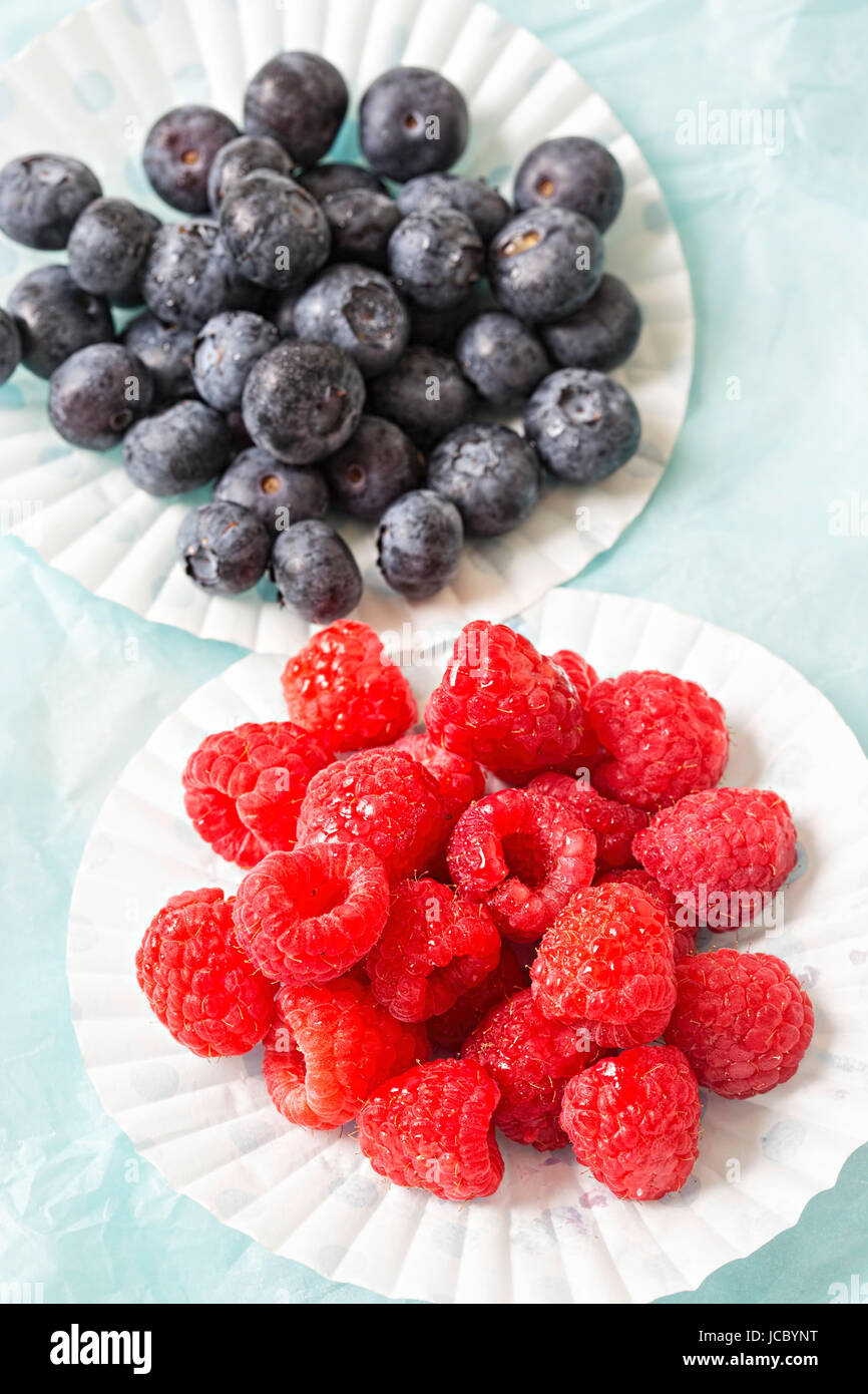 Raspberry and blueberry on blue background Stock Photo - Alamy