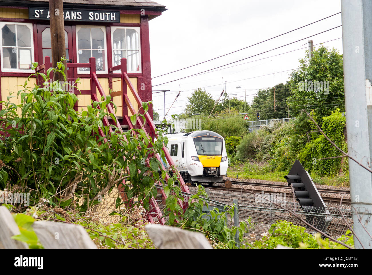 Old fashioned signal box at st albans city station with a passing train ...