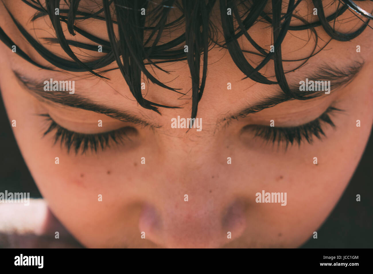 Boy with green eyes looking down Stock Photo - Alamy