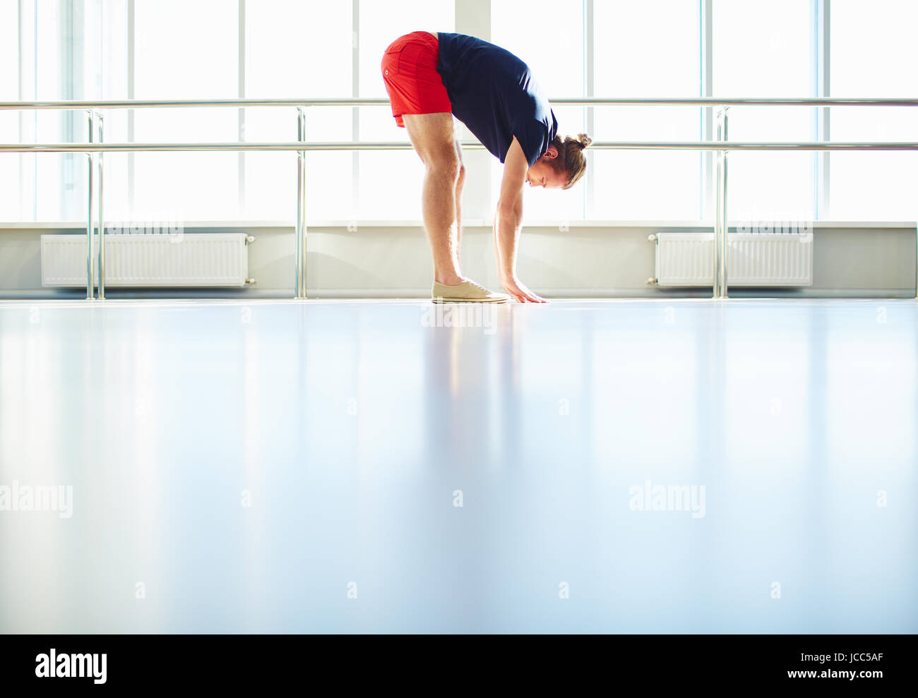 Side view of young sportsman doing physical exercises in gym Stock ...
