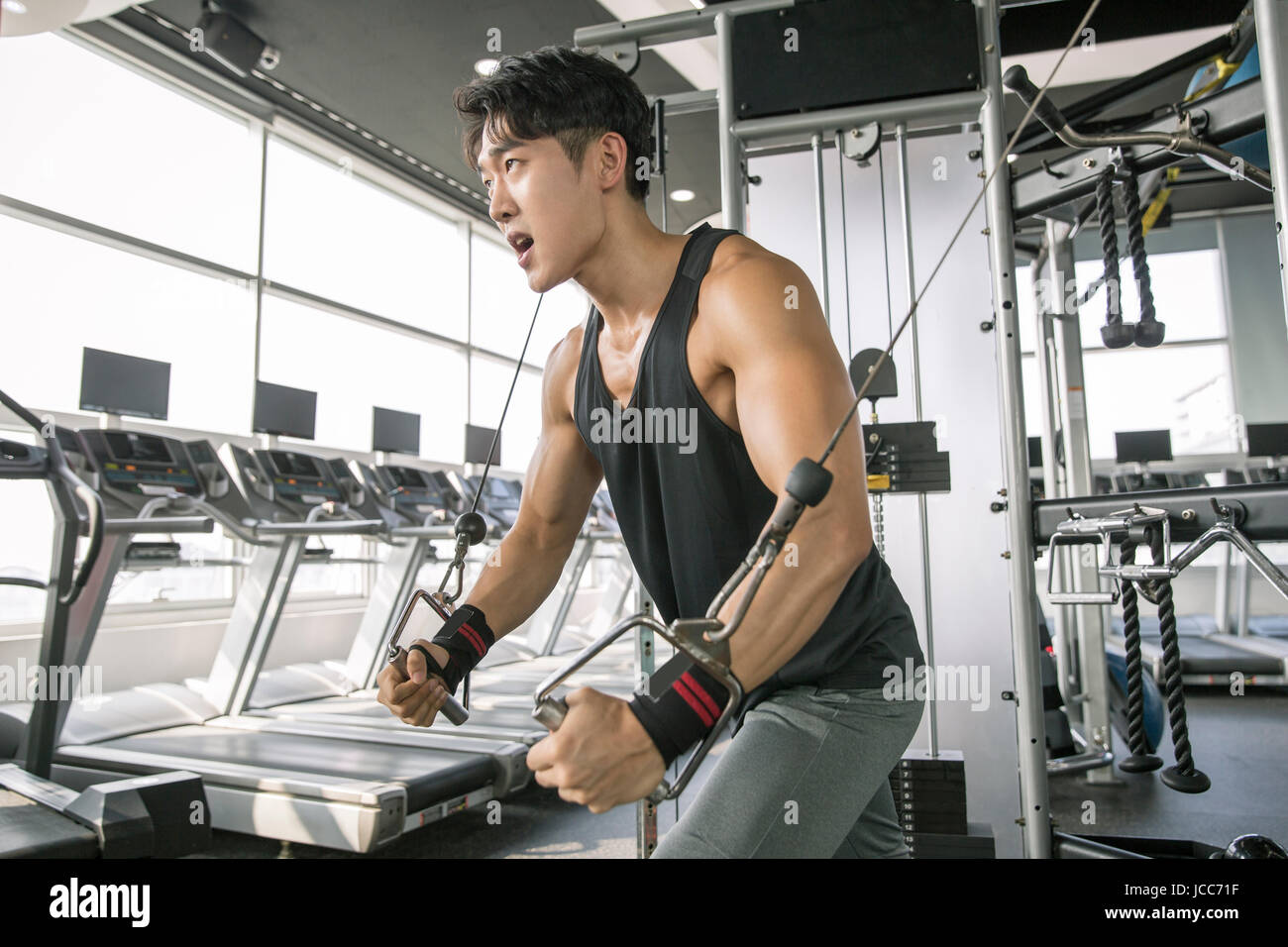 Young man exercising at health club Stock Photo - Alamy