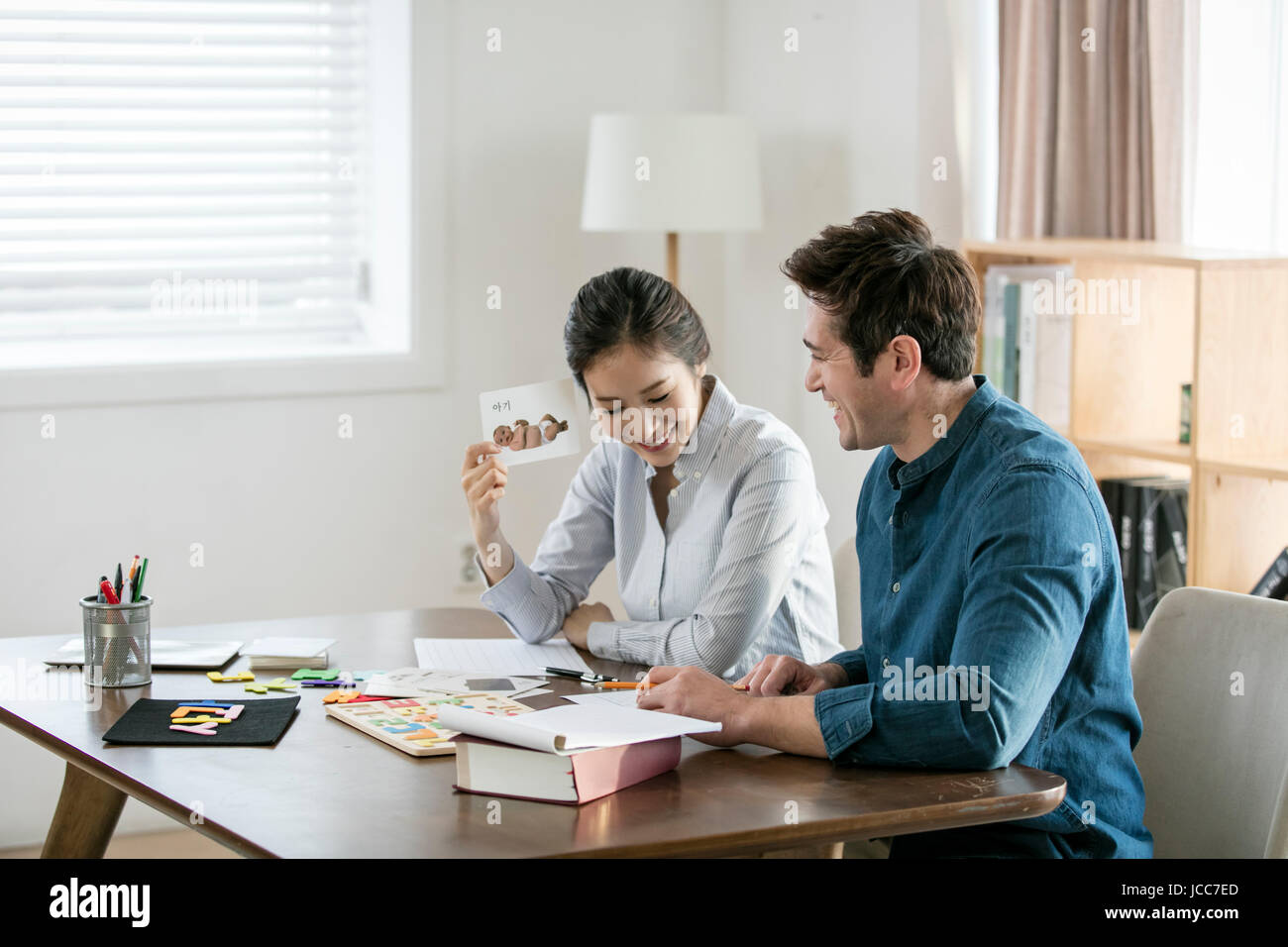 Smiling multicultural couple learning Korean Stock Photo - Alamy