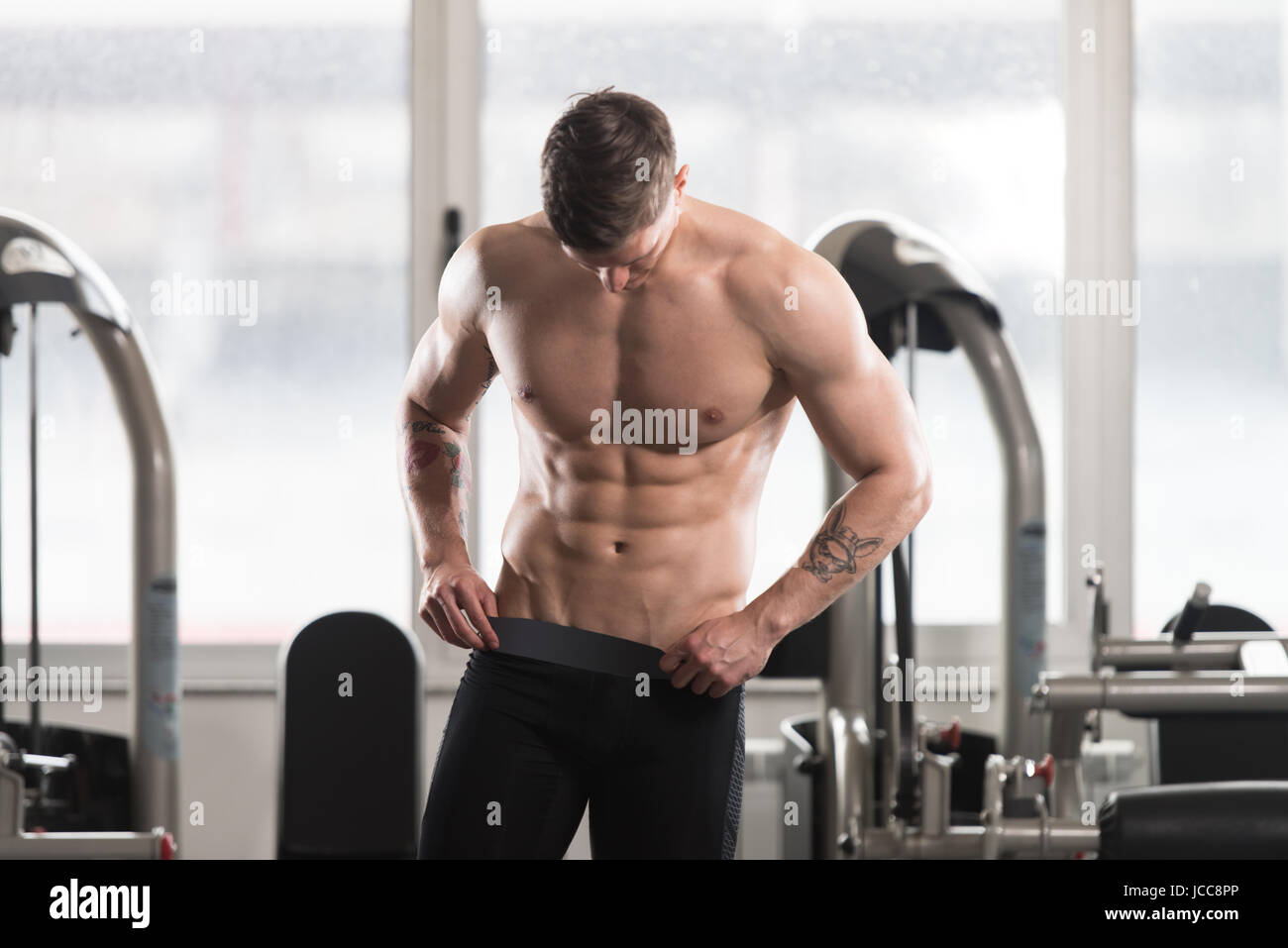 Portrait Of A Young Physically Fit Tattoo Man Showing His Well Trained ...