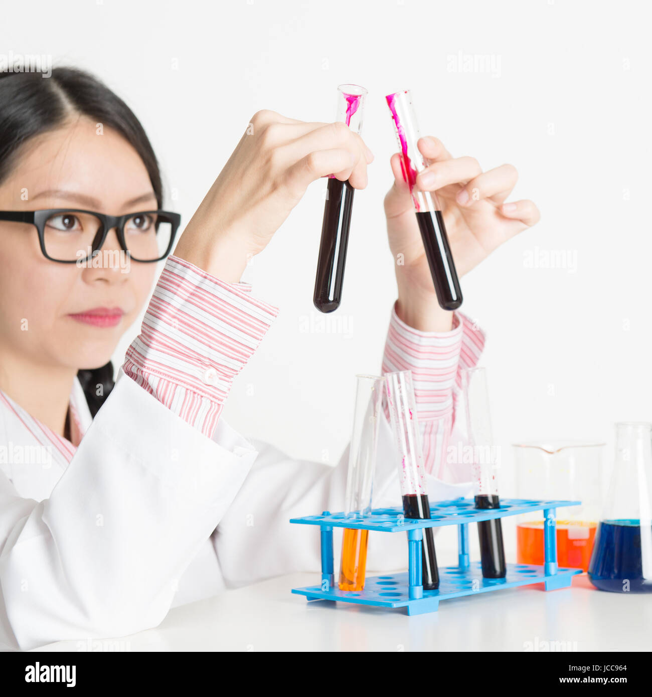 Asian lab worker doing blood test analysis, on plain background Stock ...