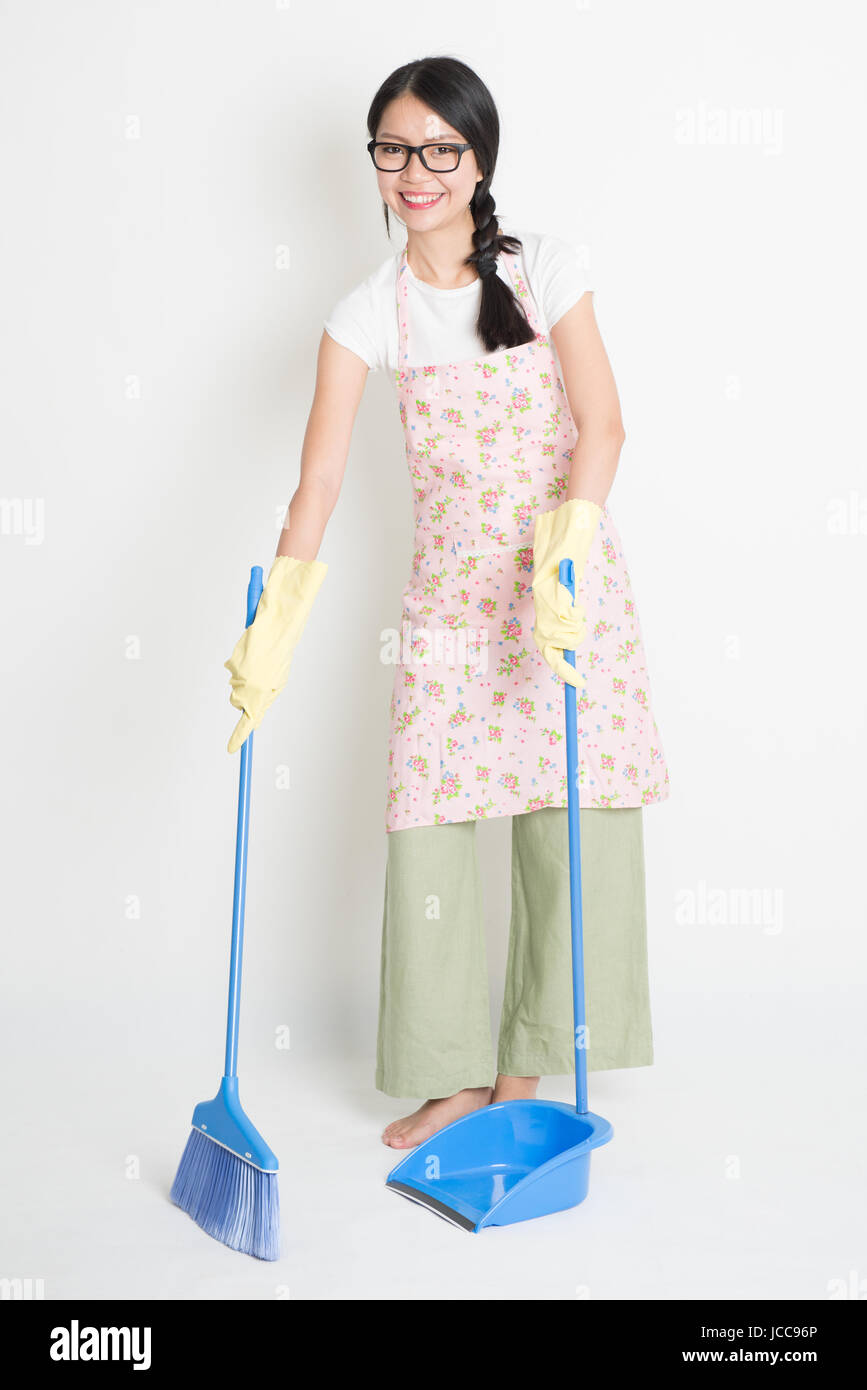 Full length Asian Chinese female housekeeping, sweeping floor with ...