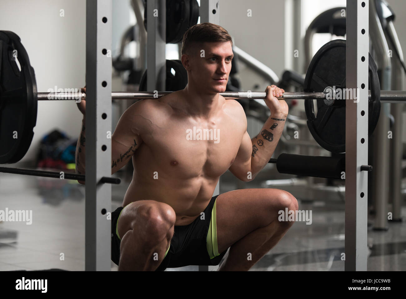 Man Working Out Legs With Barbell In A Gym - Squat Exercise Stock Photo ...