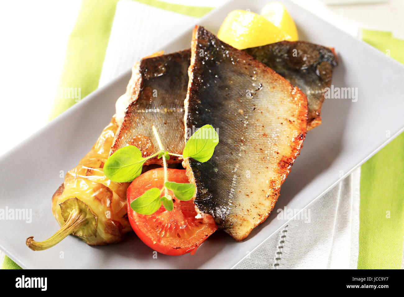 Pan fried fish fillets and vegetable garnish Stock Photo - Alamy