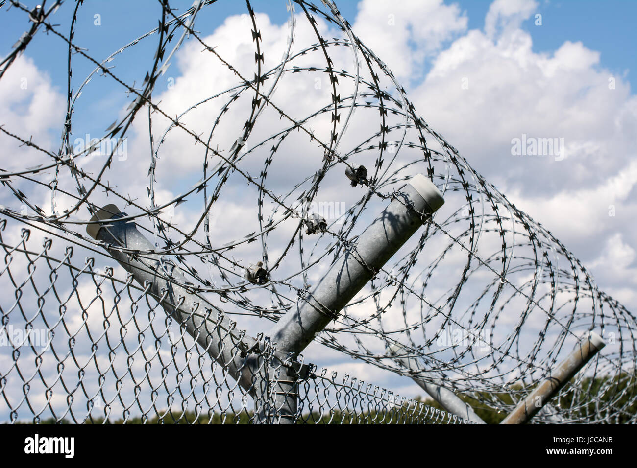 Security barrier with a barbed wire fence Stock Photo - Alamy