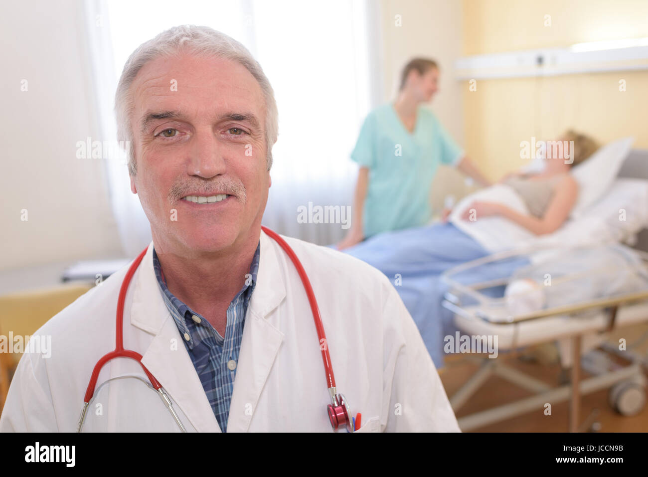 portrait of doctor standing in hospital room Stock Photo - Alamy