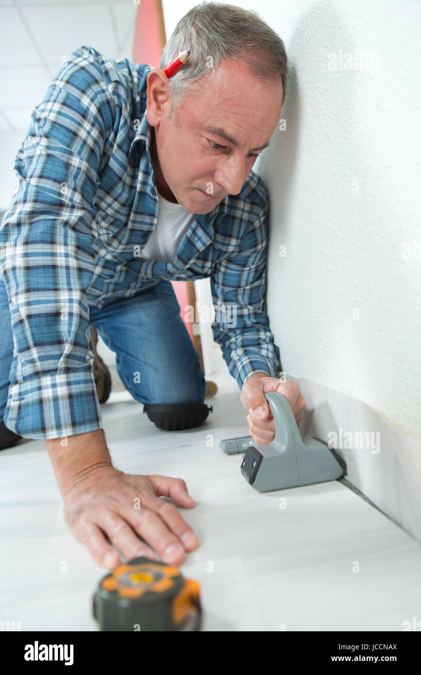 tiler marks the tile during the floor installation Stock Photo - Alamy