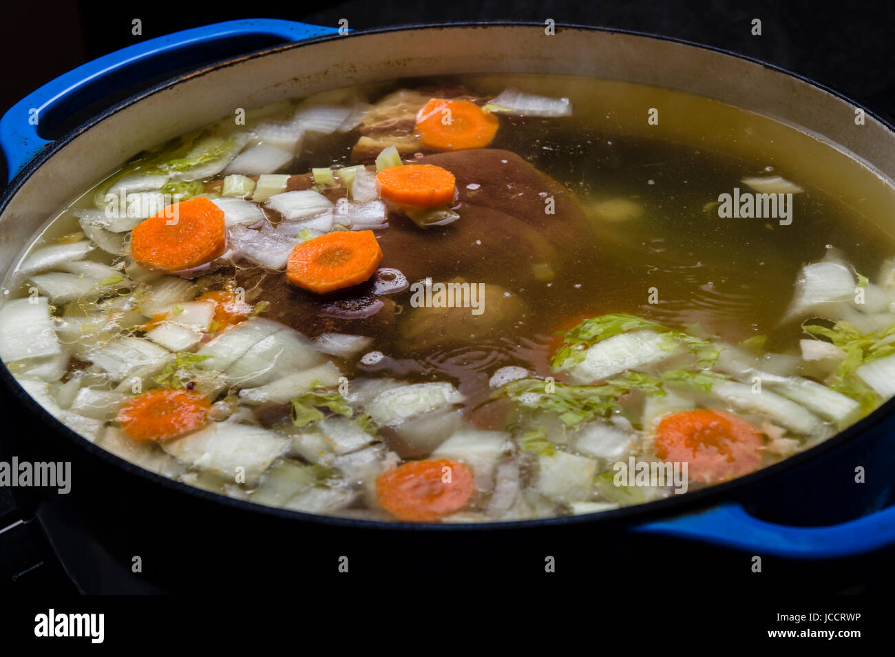 Vegetable ham soup cooking on the stove with carrots onions Stock Photo ...