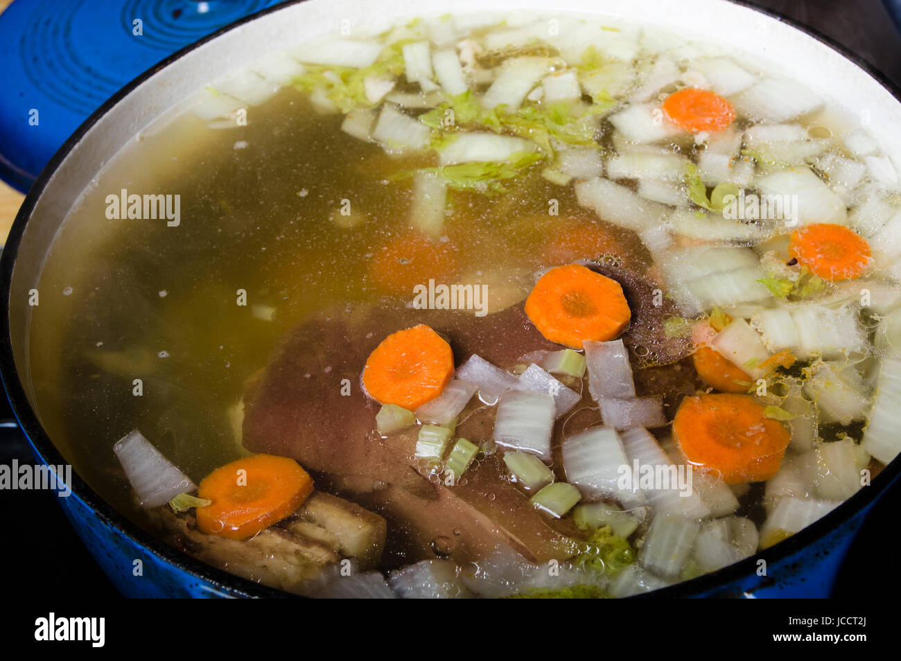 Vegetable ham soup cooking on the stove with carrots onions Stock Photo ...