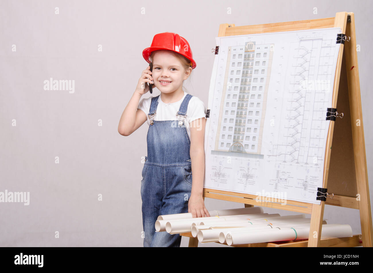 Girl playing Builder talking on the phone behind the blackboard with a ...