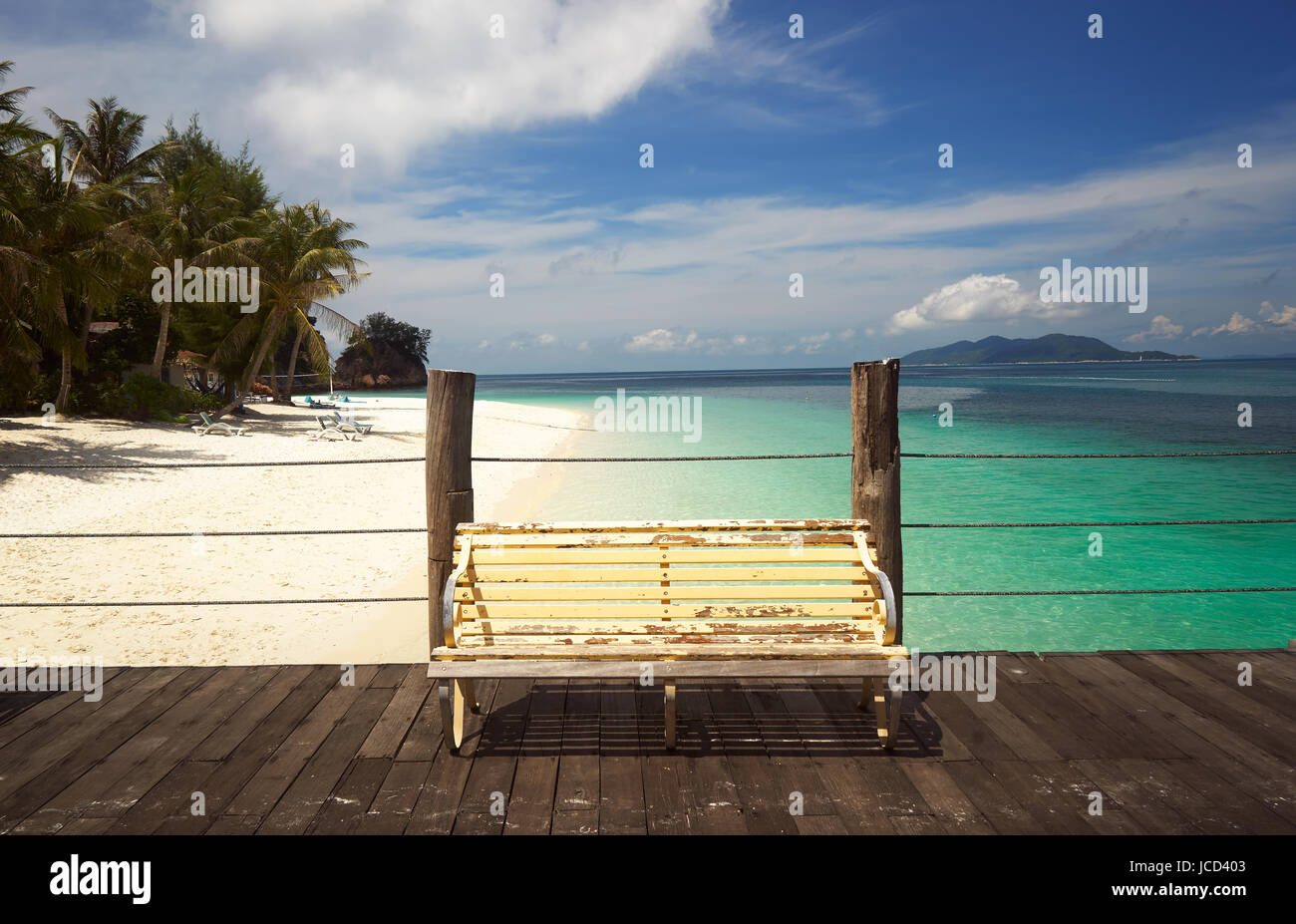 Wood deck with bench and ocean in beautiful tropical beach background ...