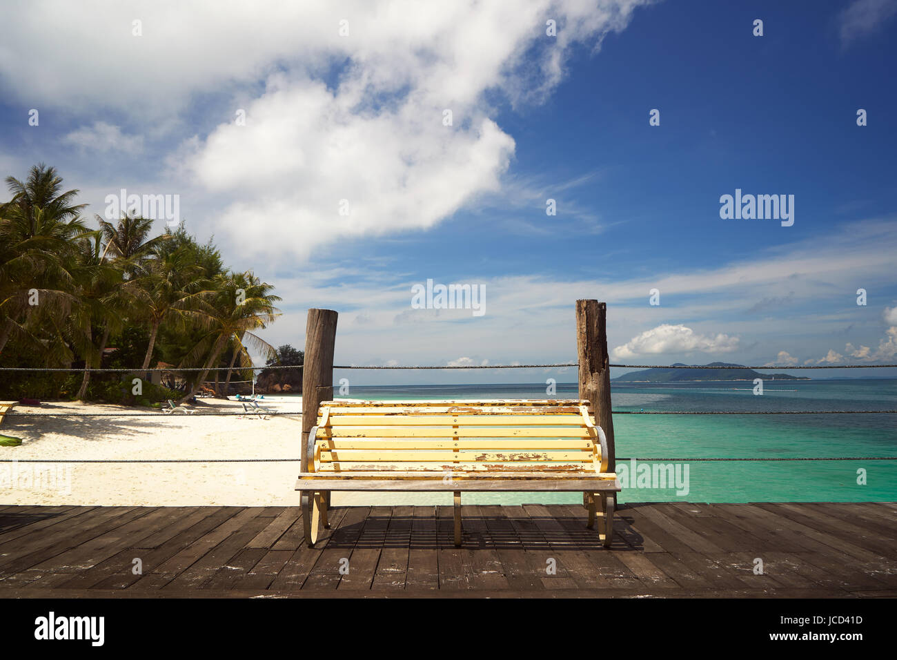 Wood deck with bench and ocean in beautiful tropical beach background ...