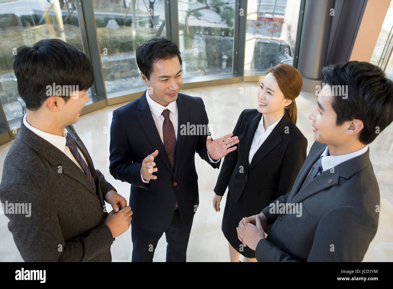 Smiling business people having talks at company Stock Photo - Alamy