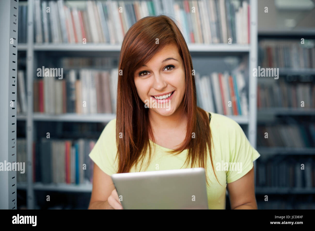 Happy student using digital tablet in library Stock Photo - Alamy