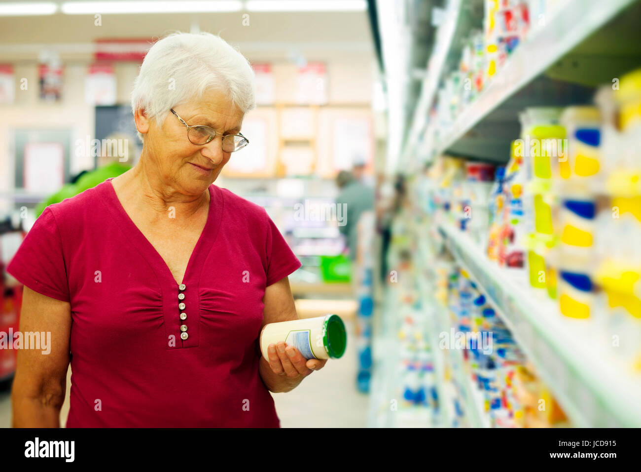 Senior woman checking label on jar Stock Photo - Alamy