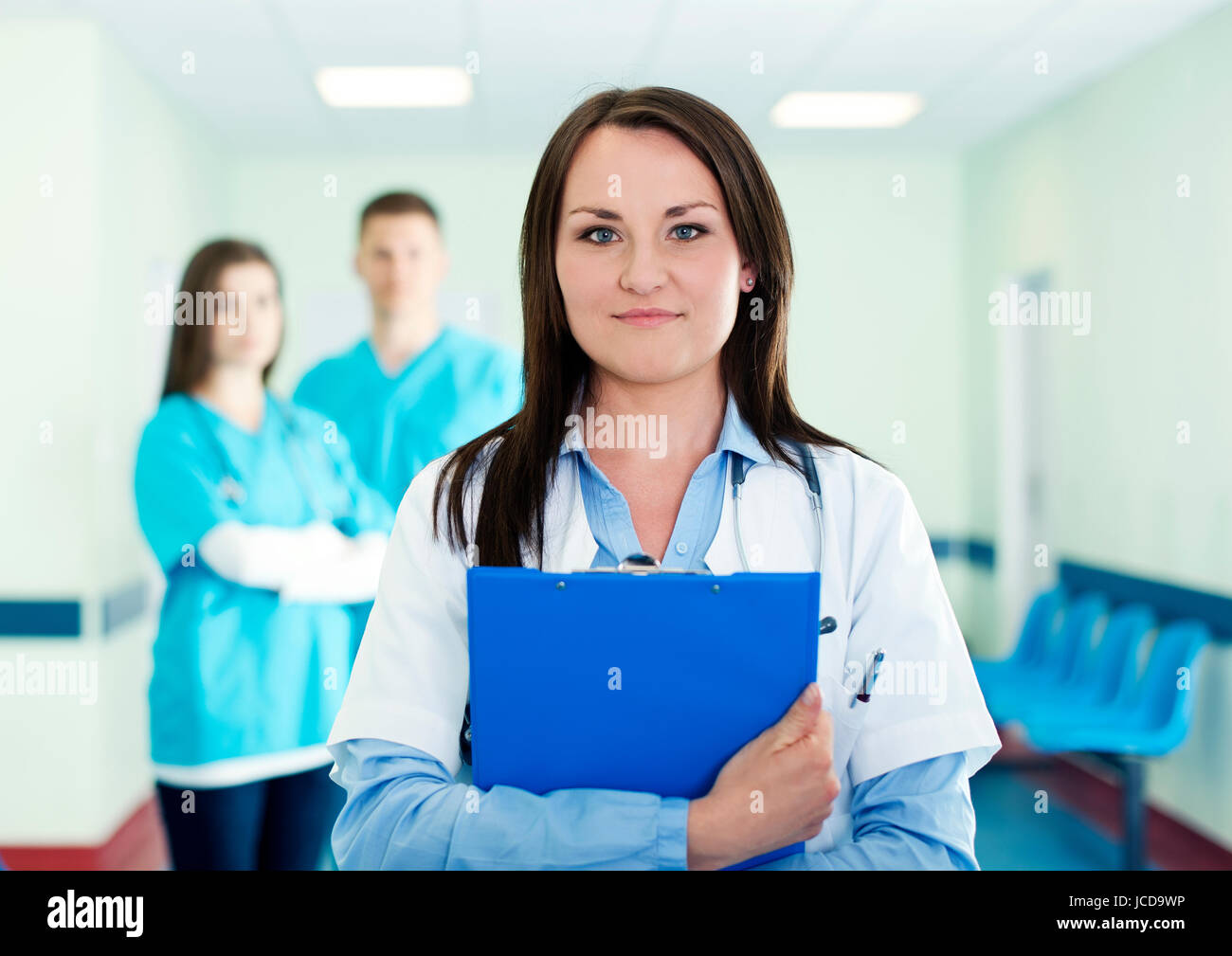 Portrait of young female doctor with interns in background Stock Photo ...