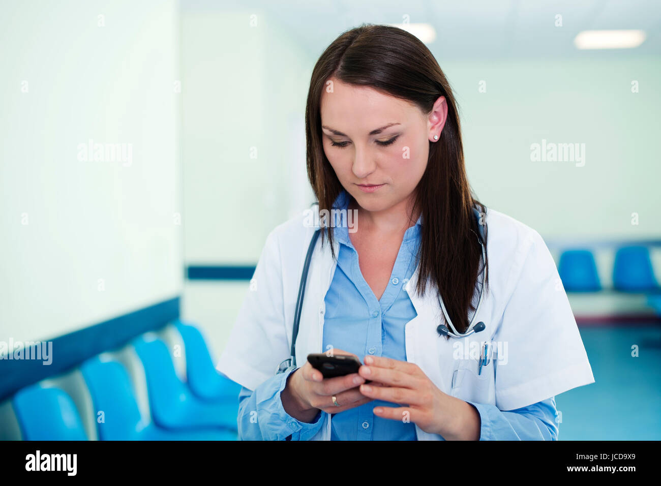 Young female doctor texting Stock Photo - Alamy