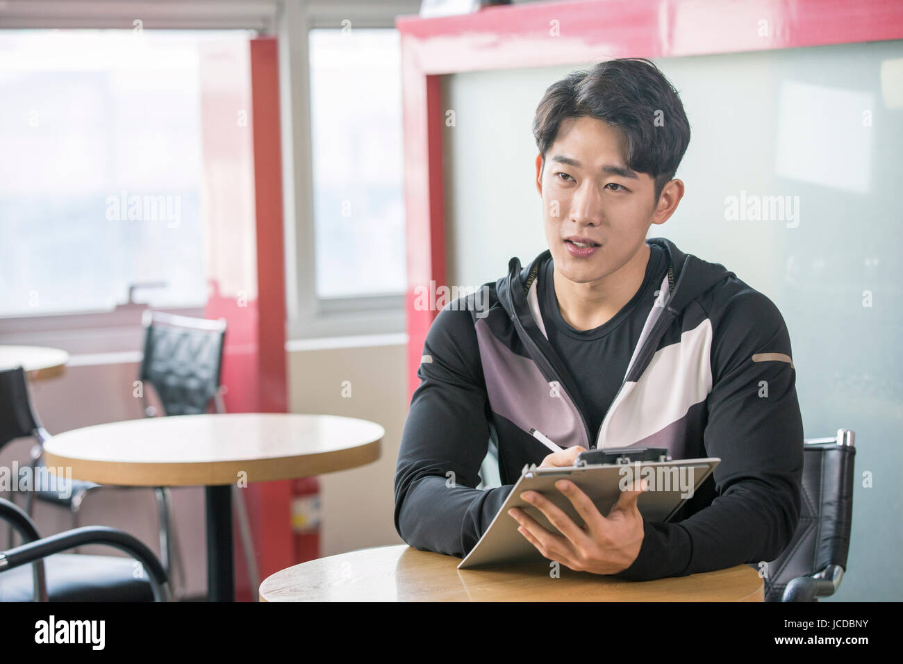 Smiling trainer at health club Stock Photo - Alamy