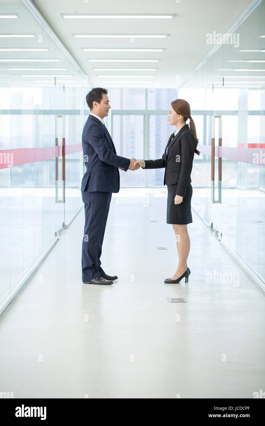 Side view of two business people making a handshake Stock Photo - Alamy