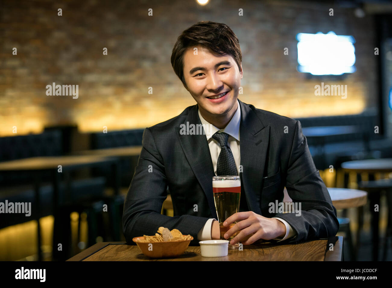 Portrait of smiling single man drinking alone Stock Photo - Alamy