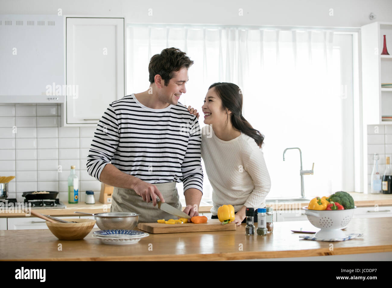 Harmonious multicultural family couple cooking Stock Photo - Alamy