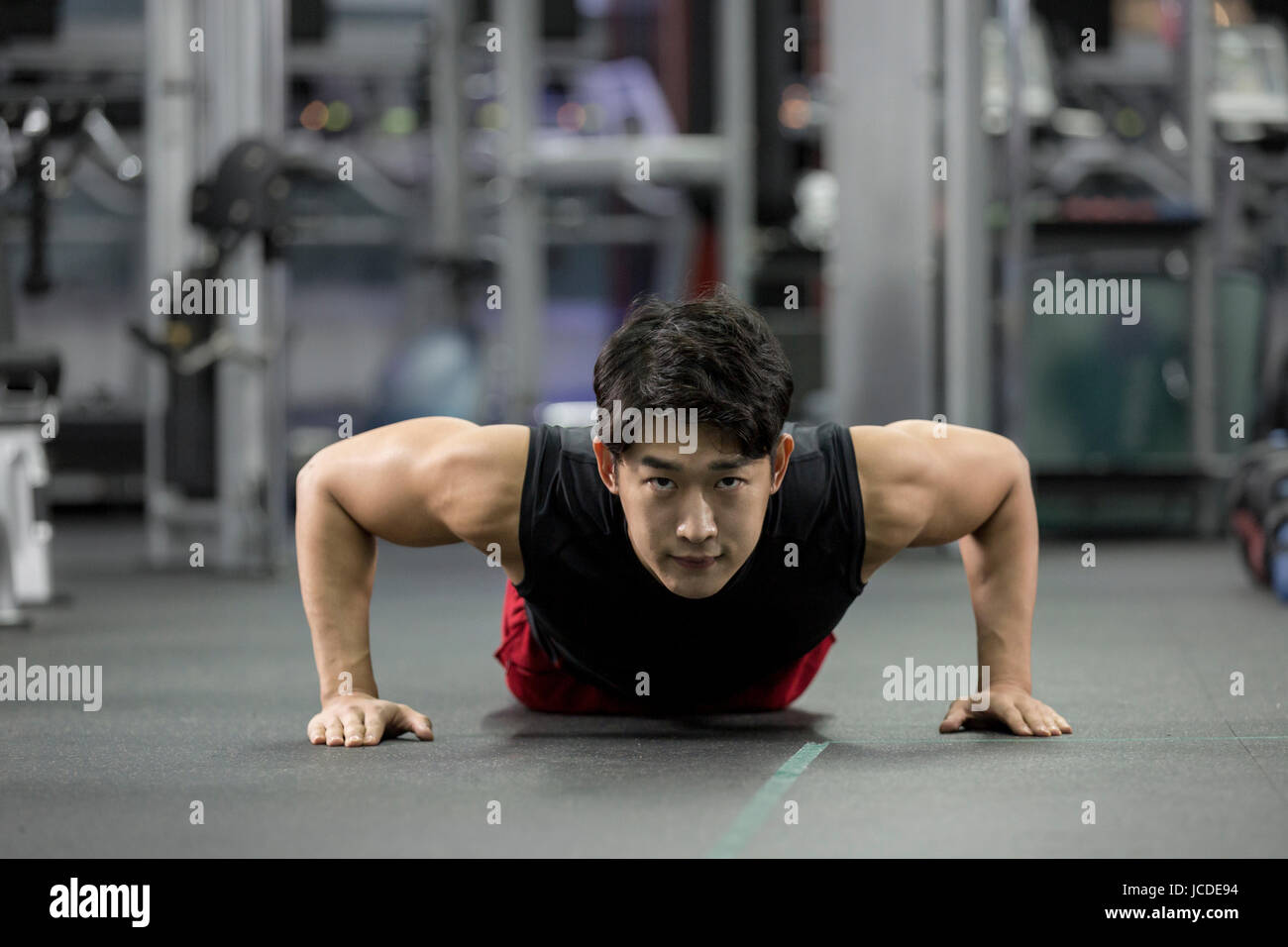 Young man pushing up at health club Stock Photo - Alamy