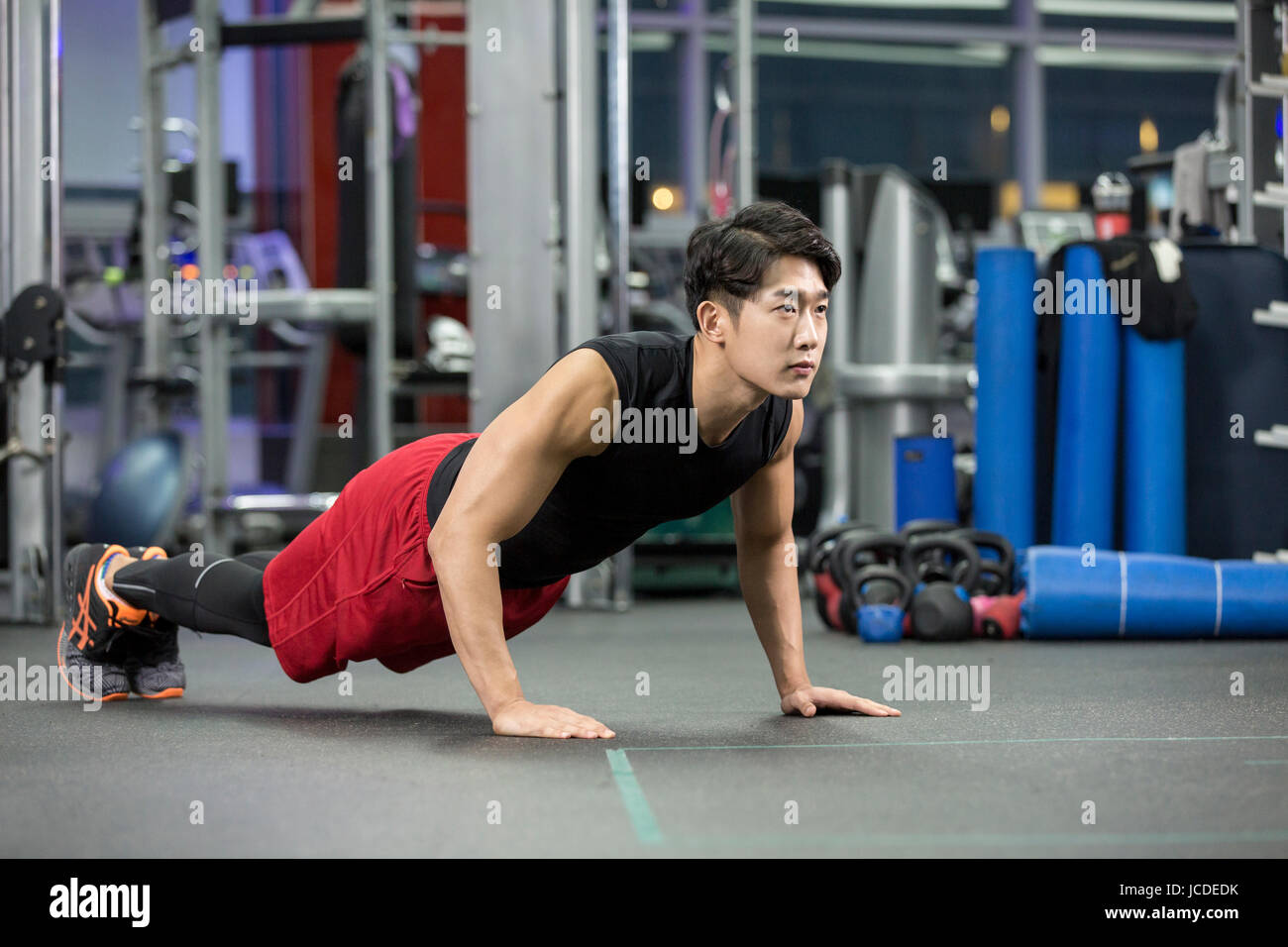 Young man pushing up at health club Stock Photo - Alamy
