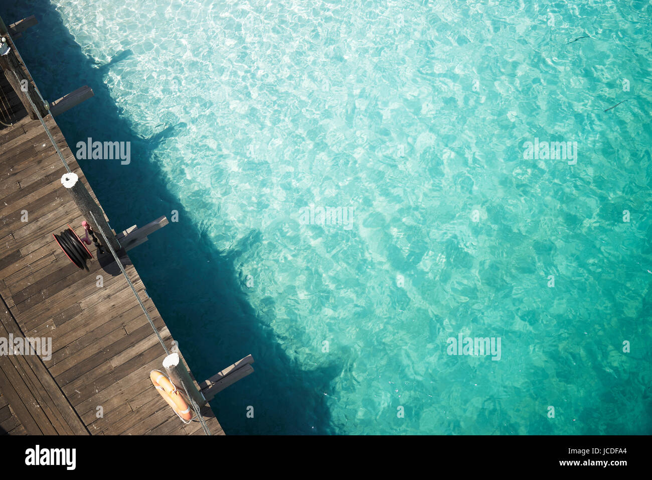 Wooden jetty with crystal clear and turquoise sea water of the tropical ...