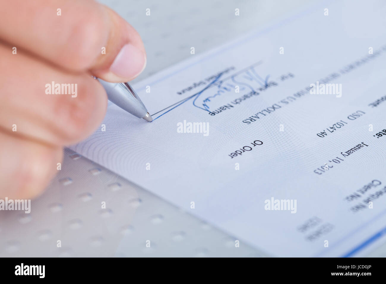 A Male Hand Filling Out The Amount On A Cheque Stock Photo - Alamy