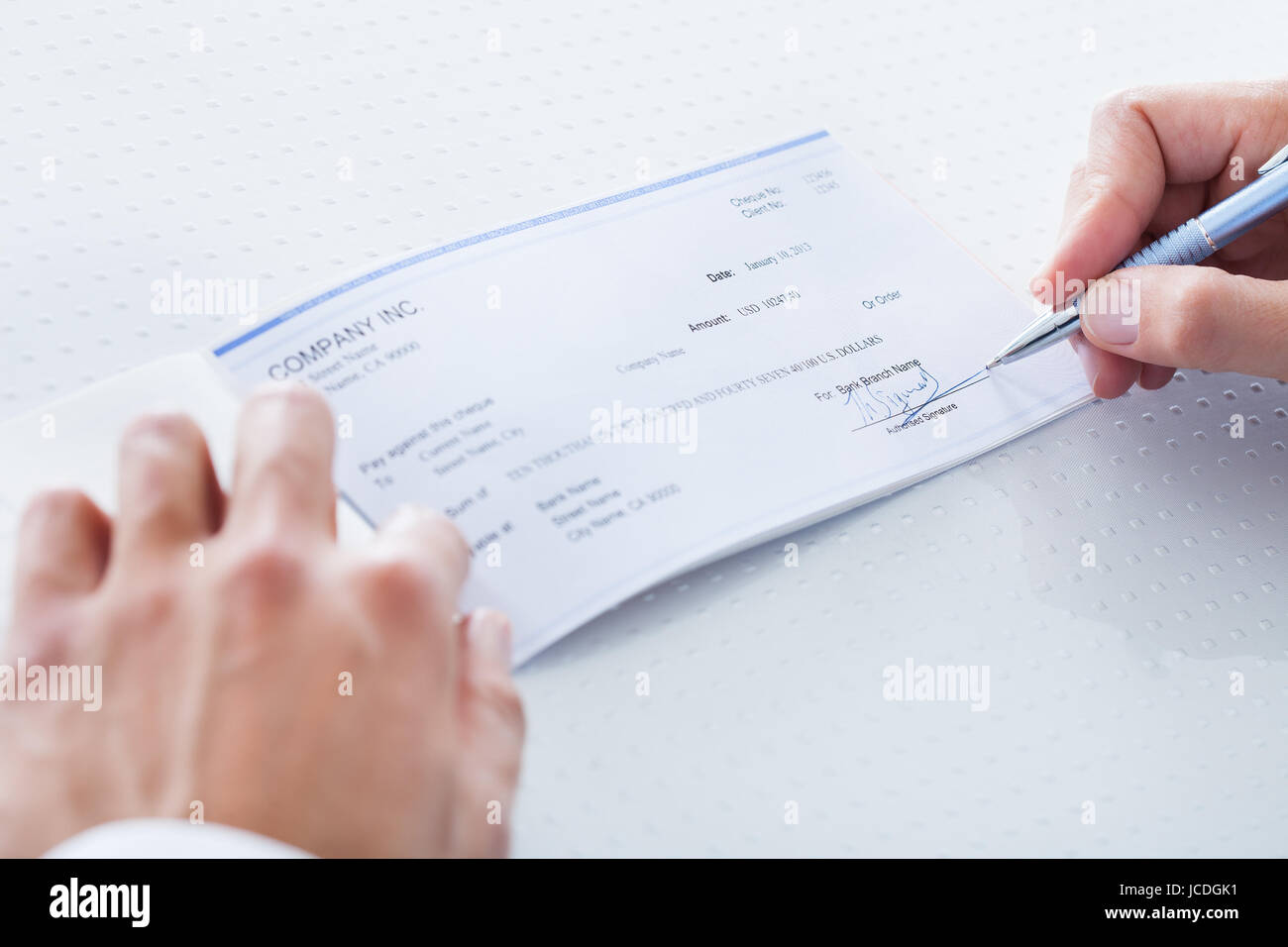 A Male Hand Filling Out The Amount On A Cheque Stock Photo - Alamy