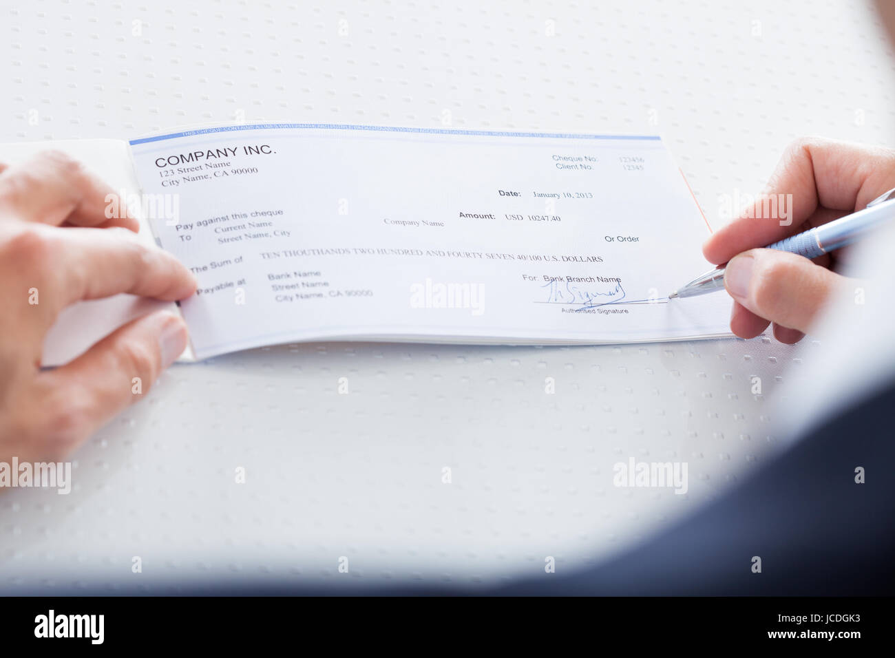 A Male Hand Filling Out The Amount On A Cheque Stock Photo - Alamy