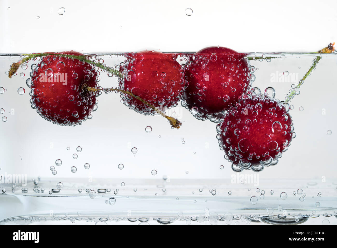 Floating in bubble water ripe cherries Stock Photo - Alamy