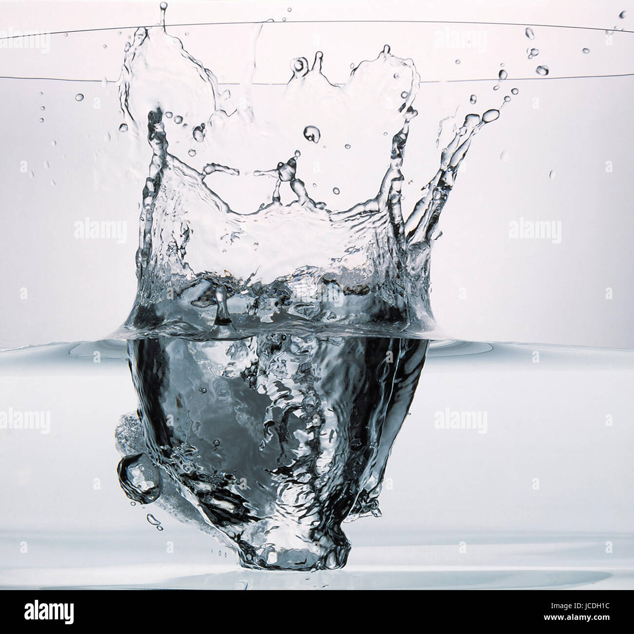 Ice cubes falling into the water surface Stock Photo - Alamy