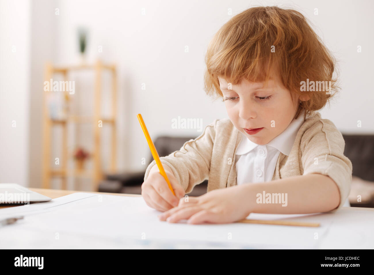 Very concentrated boy drawing picture Stock Photo - Alamy