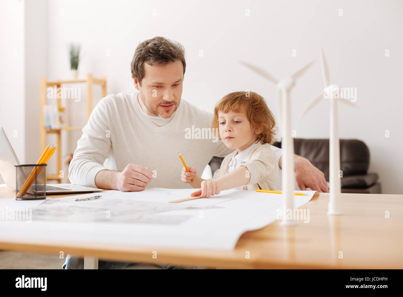 Competent engineer looking at the process of his son Stock Photo - Alamy