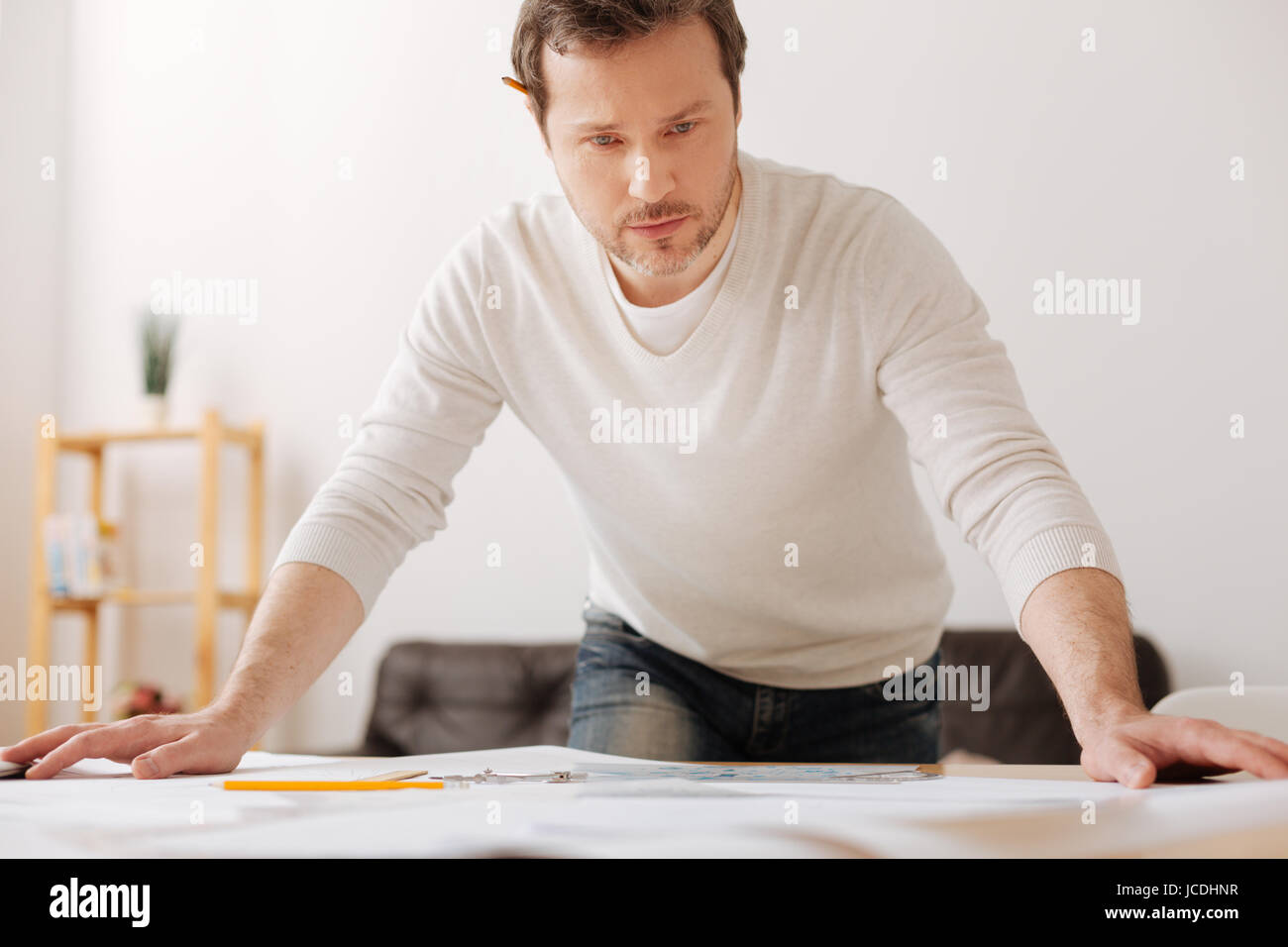 Serious male person leaning on the table Stock Photo - Alamy