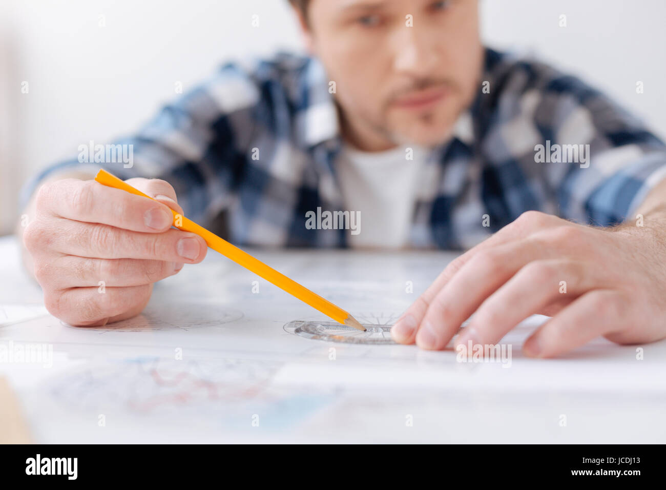 Very attentive man working with protractor Stock Photo - Alamy