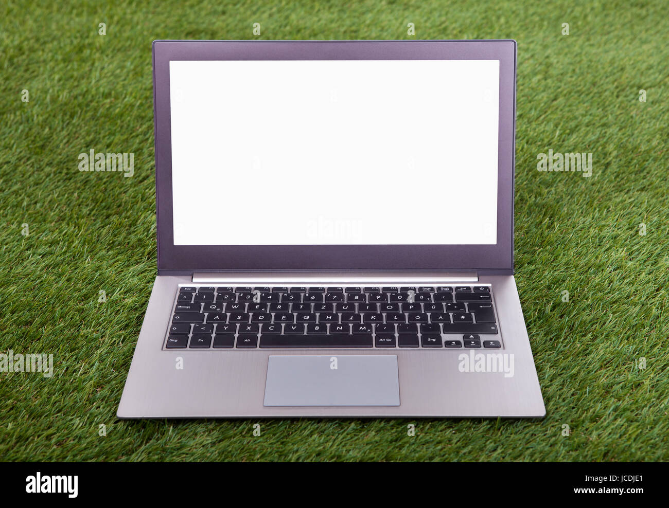 Silver Laptop Placed On Green Grass Field Stock Photo - Alamy