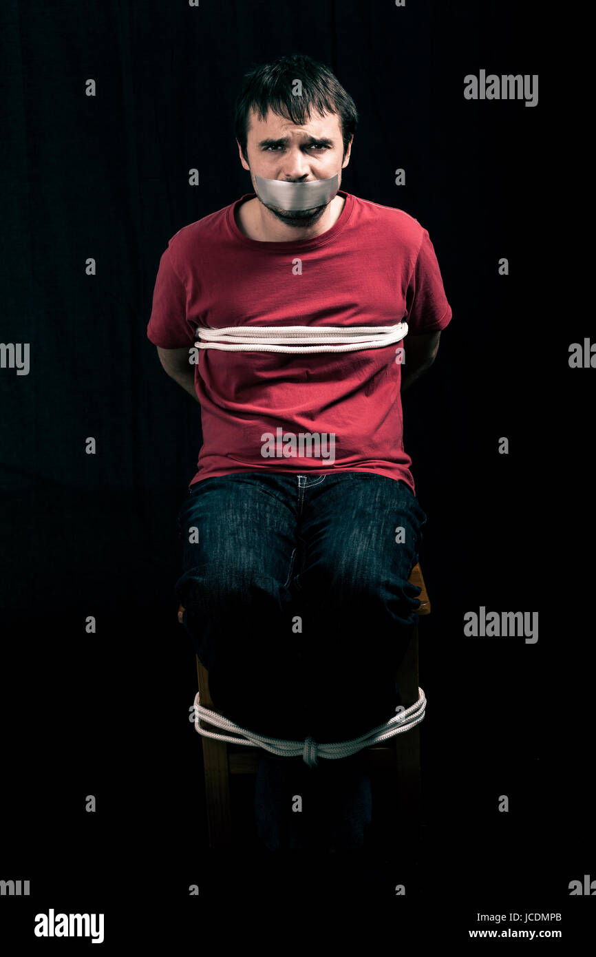 Kidnapped man hostage with tape over mouth and tied up with rope Stock ...