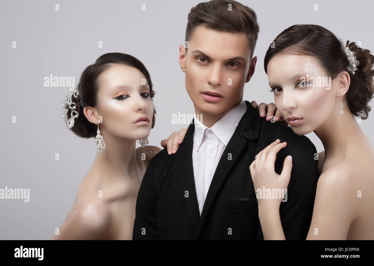 Love Triangle. Two Charming Women Hugging a Handsome Man Stock Photo ...