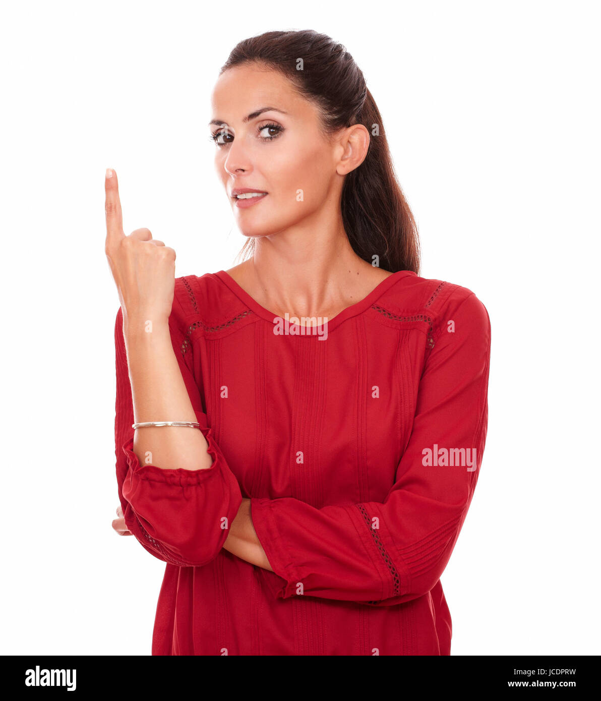 Portrait of charming female pointing up her finger while smiling at you ...