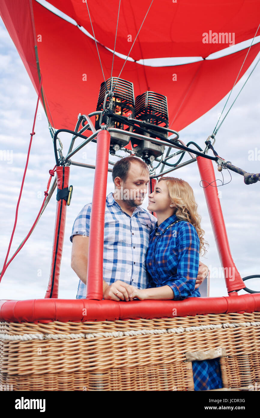 Beautiful romantic couple hugging at meadow. hot air balloon on a ...