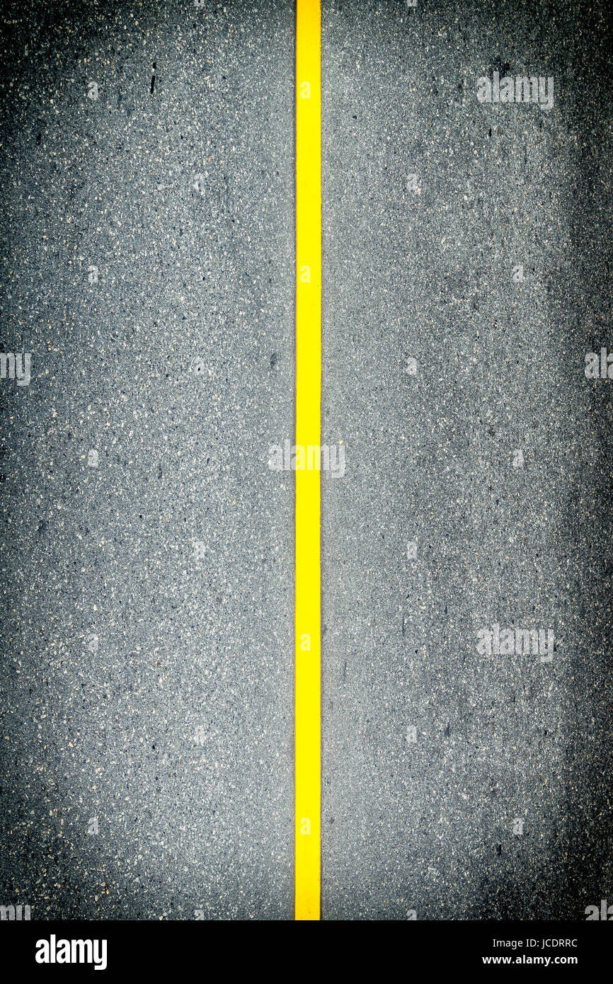 Closeup yellow center line on road background Stock Photo - Alamy